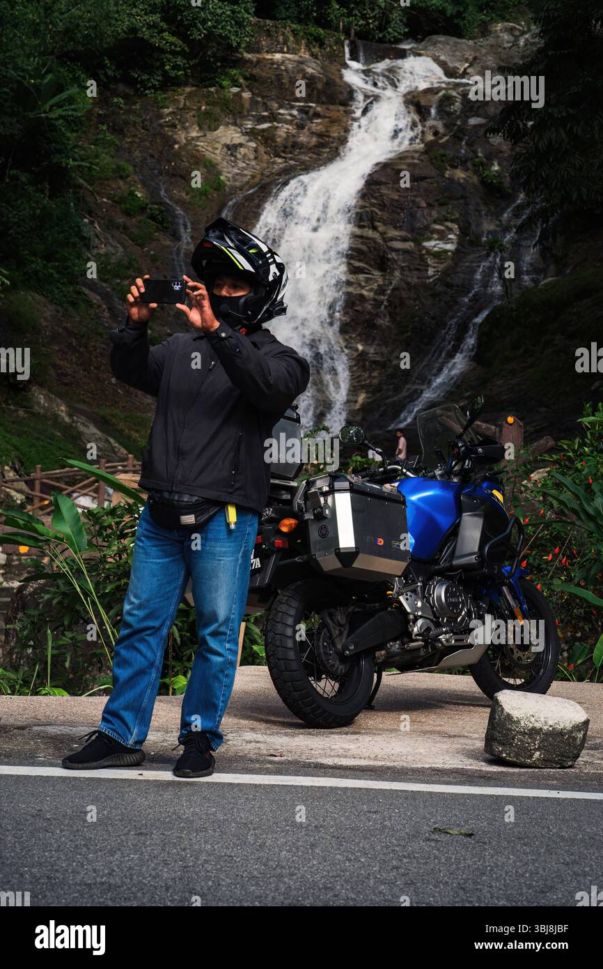 Perak, Malaysia - September 15, 2022 A biker wearing helmet is taking ...