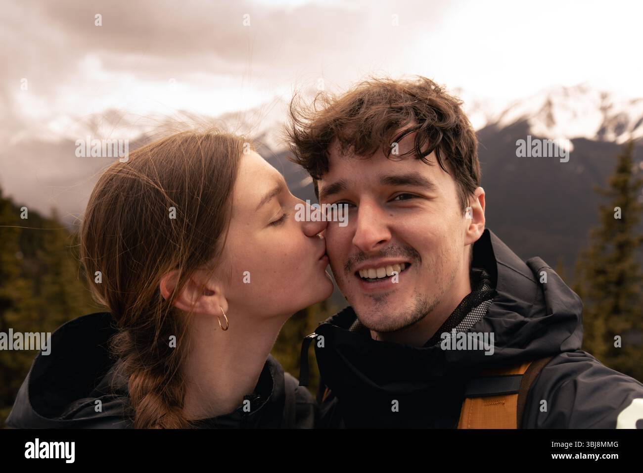 A couple shares a kiss on the cheek in Banff Stock Photo - Alamy