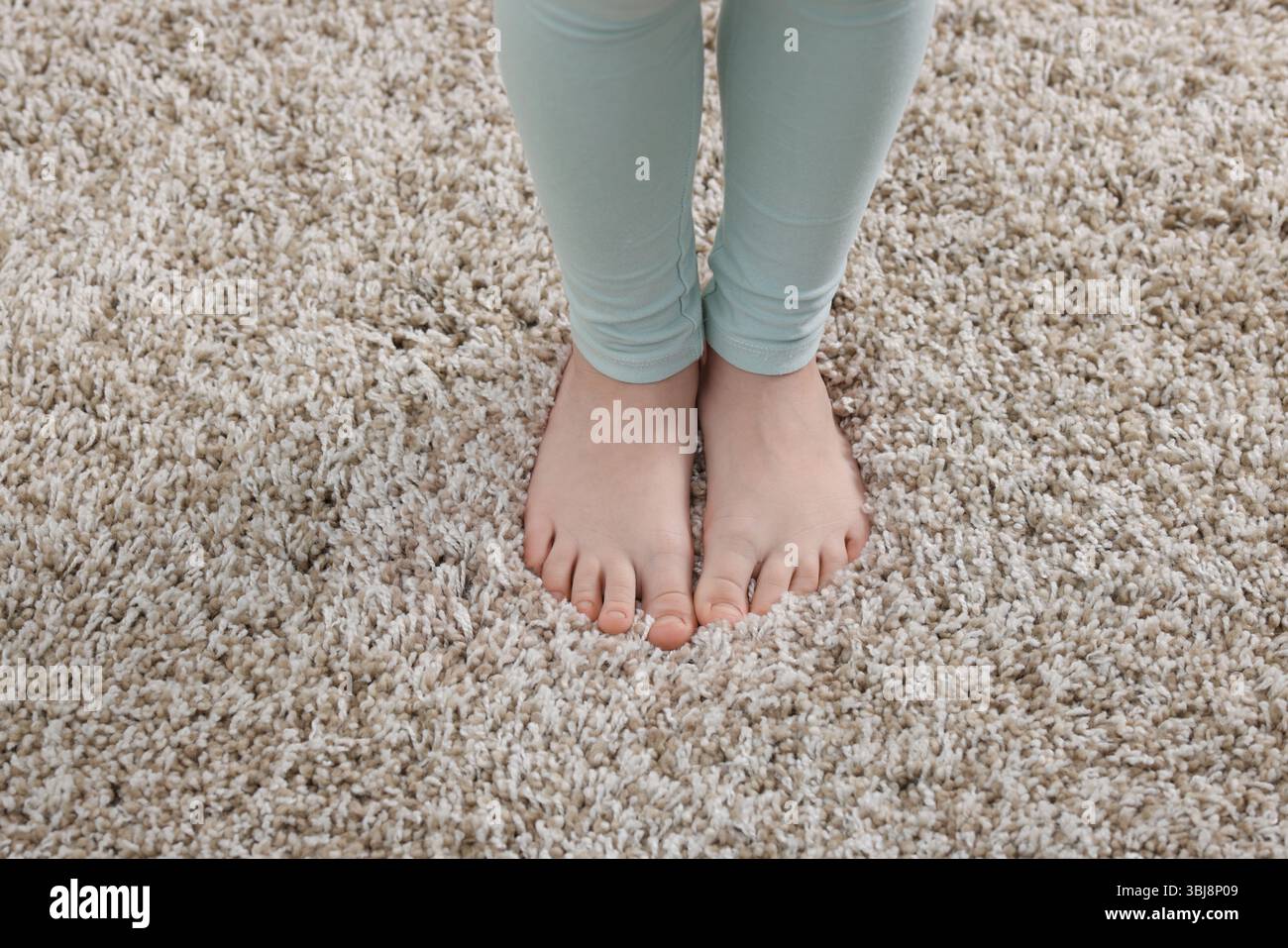 Girl on soft carpet at home, above view Stock Photo - Alamy