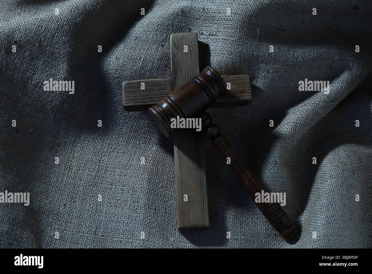 Judge's gavel and wooden cross on burlap fabric, top view Stock Photo ...