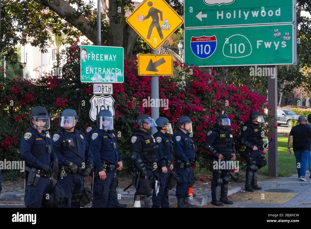 A group of officers in full riot gear stand in tight formation during ...