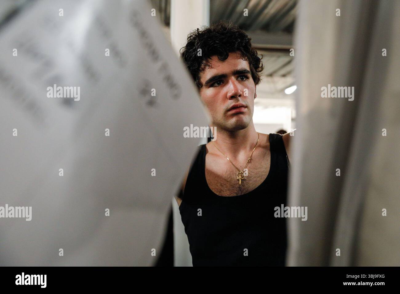 London, UK. 13th June, 2025. A model looks through the rows of outfits ...