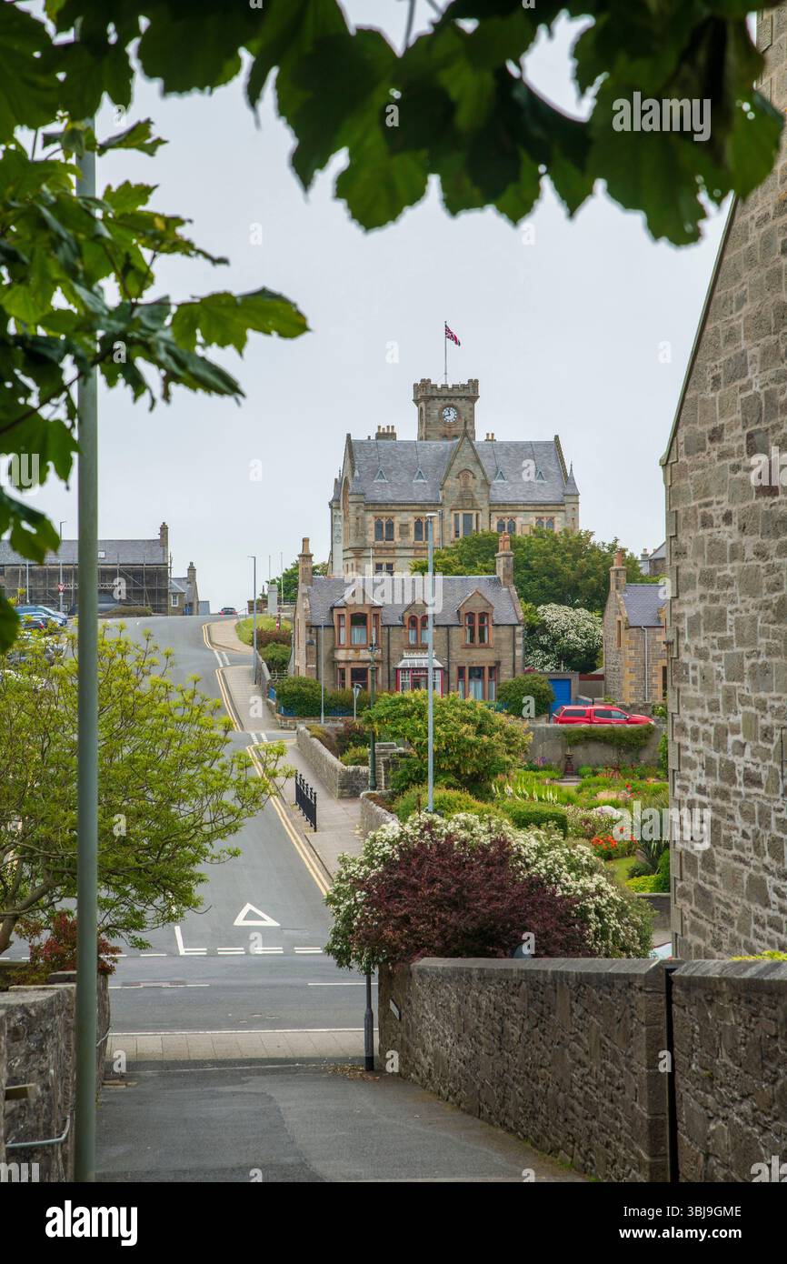 A view of Lerwick Town Hall framed by one of the narrow lanes of ...