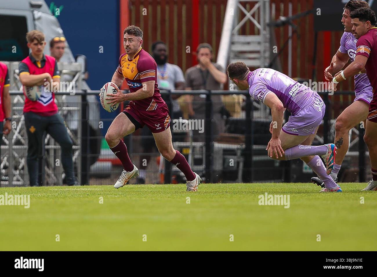Liam Clune makes a break for Huddersfield *** during the Super League ...