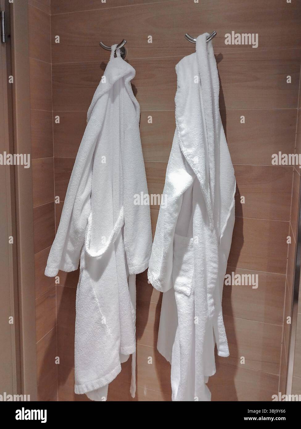 Two white robes on a rack in the hotel bathroom Stock Photo - Alamy