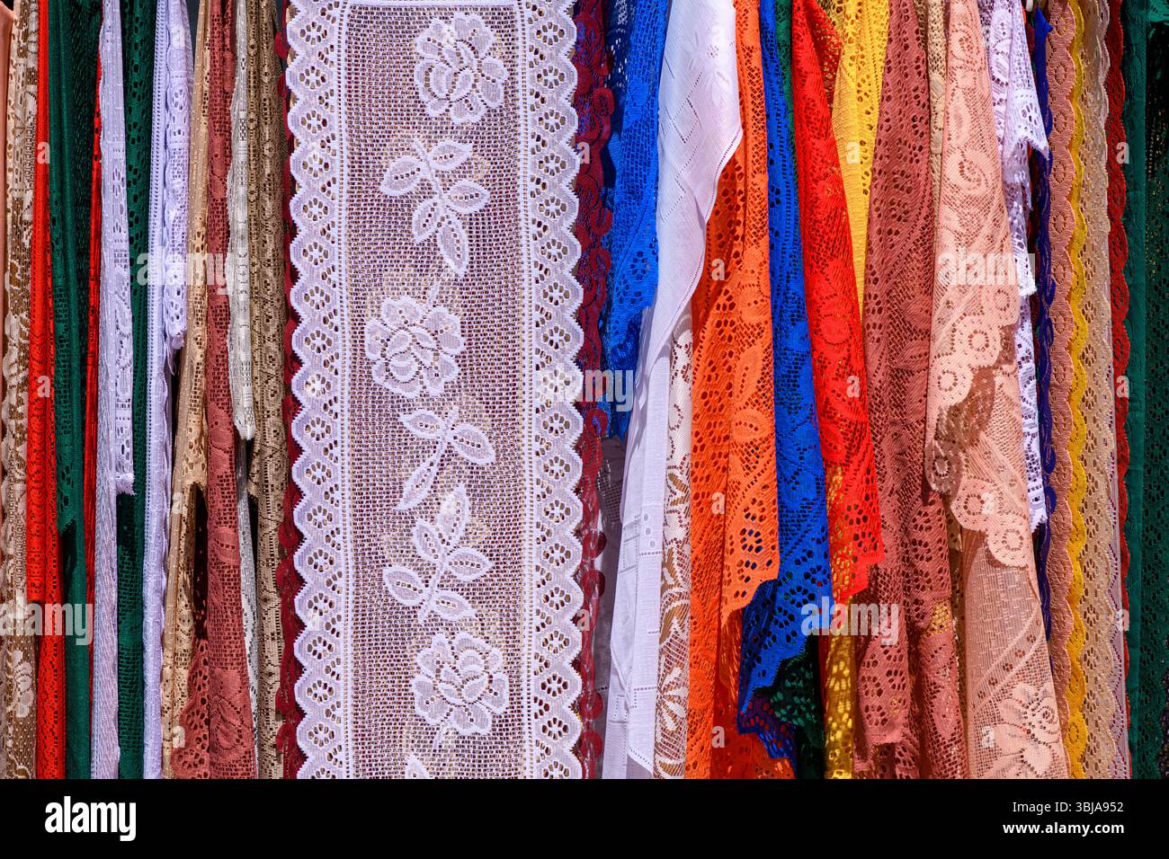 Colorful traditional lace fabrics hanging in a street market in Brazil ...