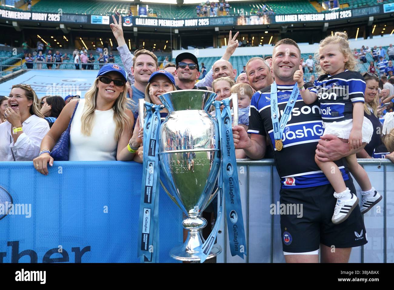 Bath Rugby's Finn Russell with daughter Charlie as he holds the trophy after victory in the ...