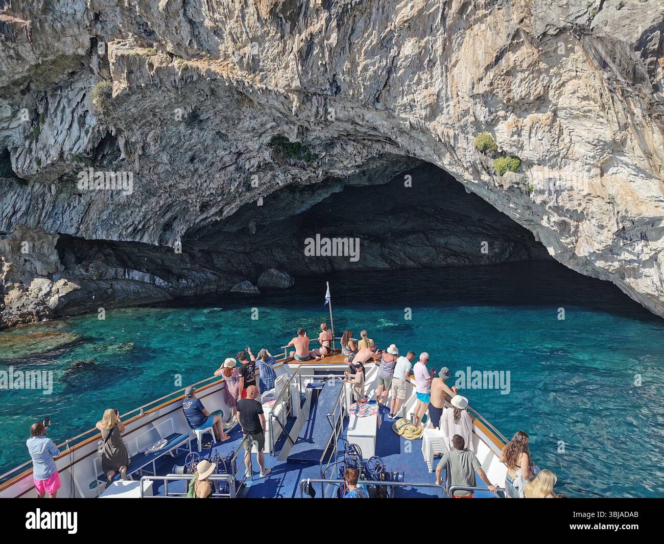 A tourist cruise boat enters the Papanikolis Cave on the south west ...