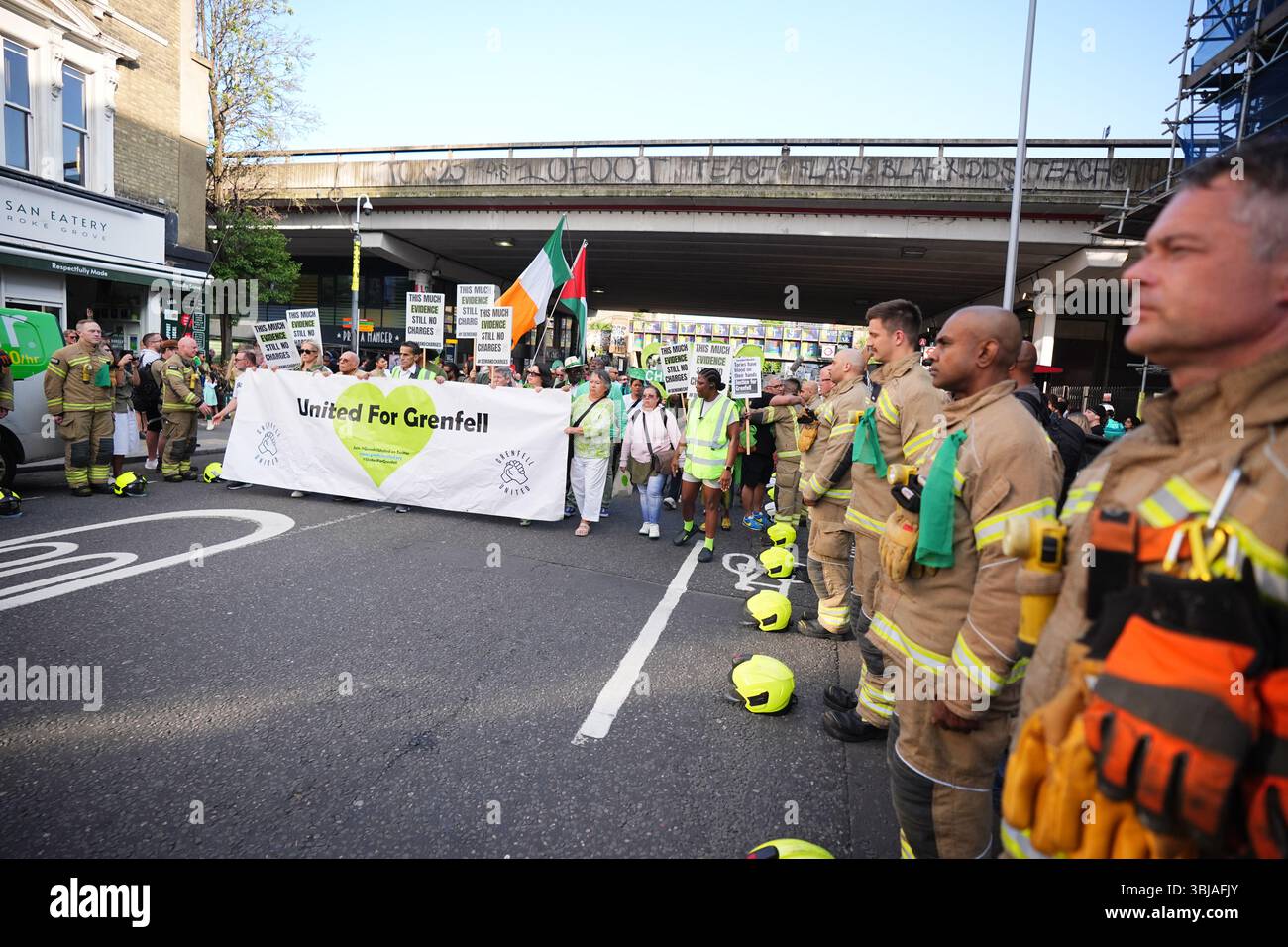 Firefighters line the street as people take part in a silent march in ...