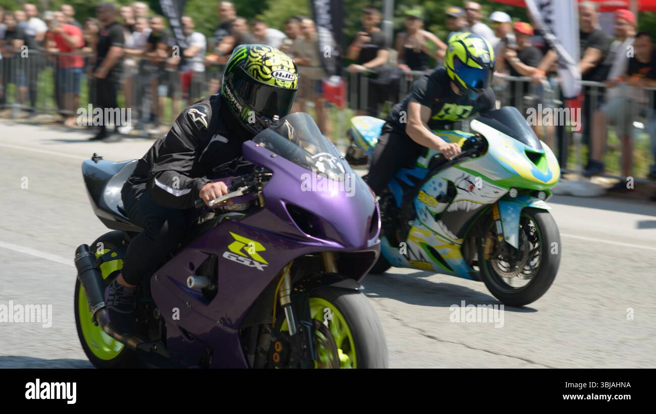 Two sportbike riders accelerate side by side during a motorcycle drag ...