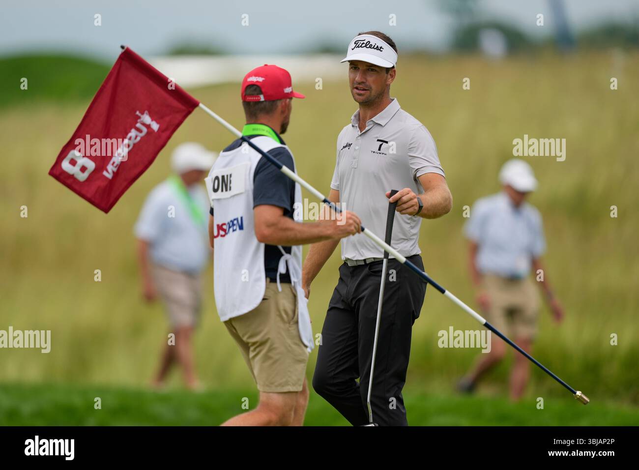 Trevor Cone hands a club off to his caddie, Dan Woodbury, left, after ...
