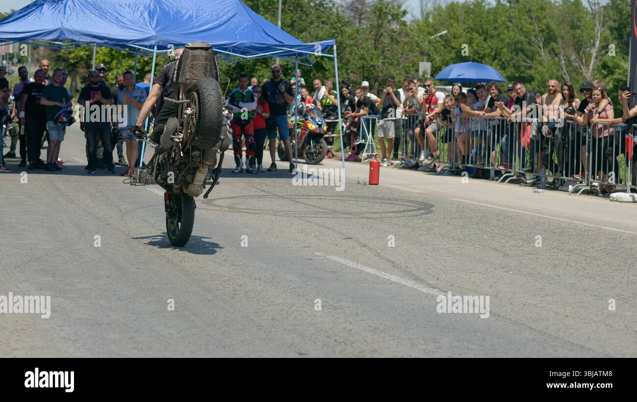 A stunt rider from the Extreme Attack team performs a rear wheelie on a ...