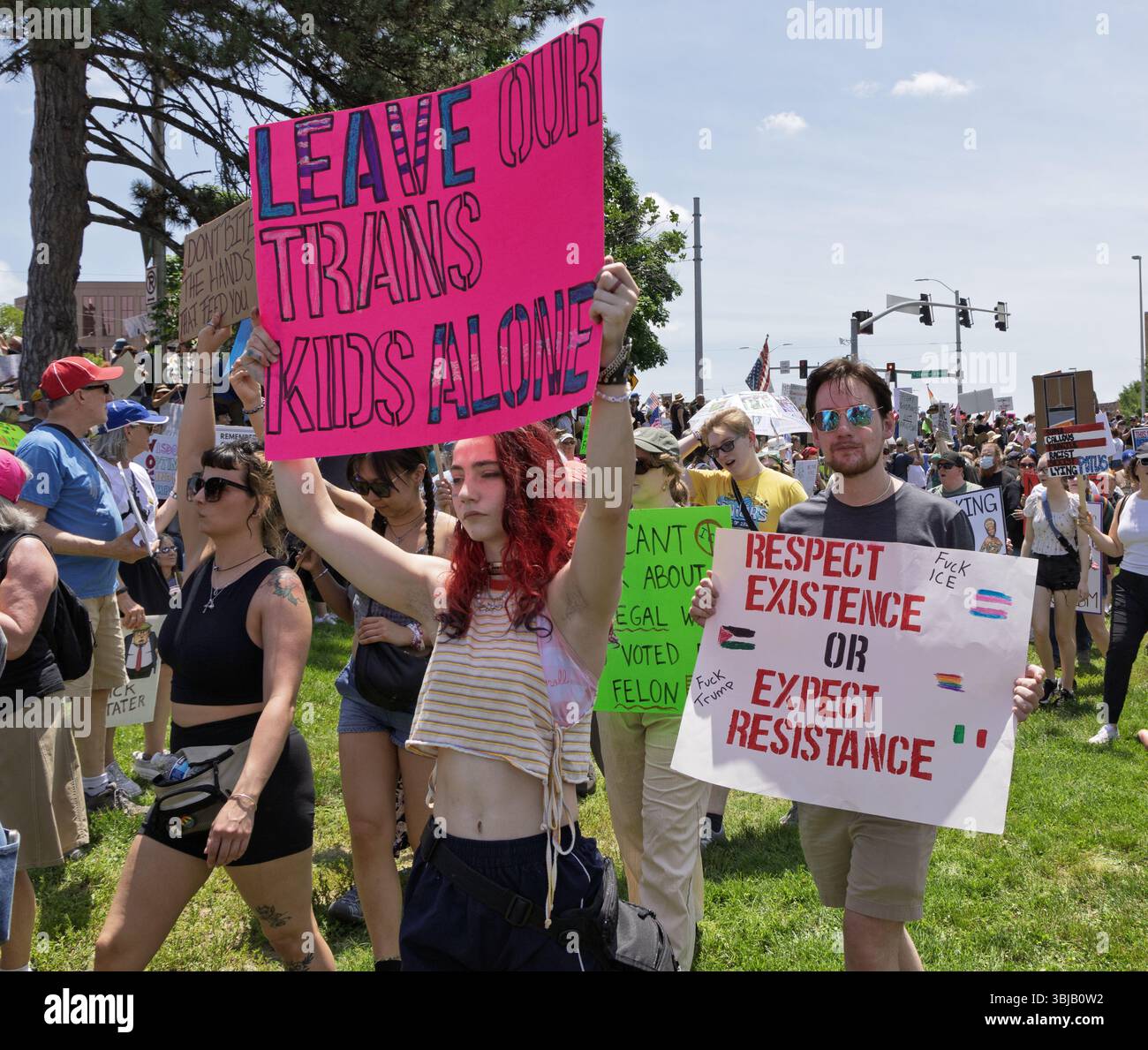 A diverse group of protesters march holding signs advocating for ...