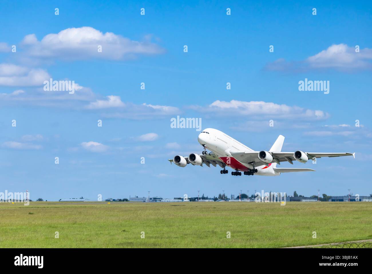 Modern passenger airliner gaining altitude after takeoff from runway at ...