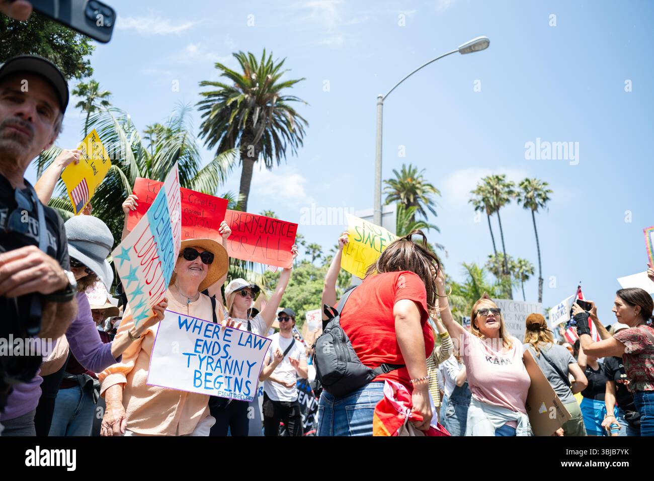 Santa Monica, USA. 14th June, 2025. People hold up placards at a "No ...