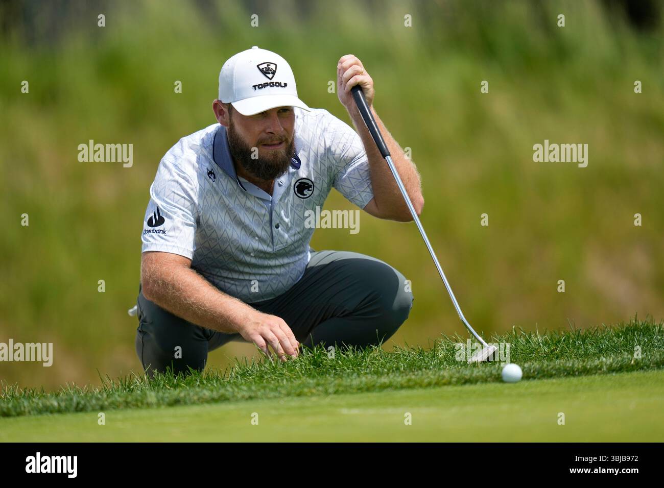 Tyrrell Hatton, of England, lines up a putt on the second hole during ...