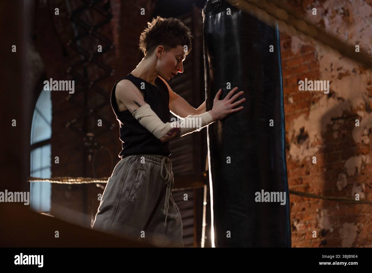 Short-haired fighter in boxing ring, cinematic rest moment between ...