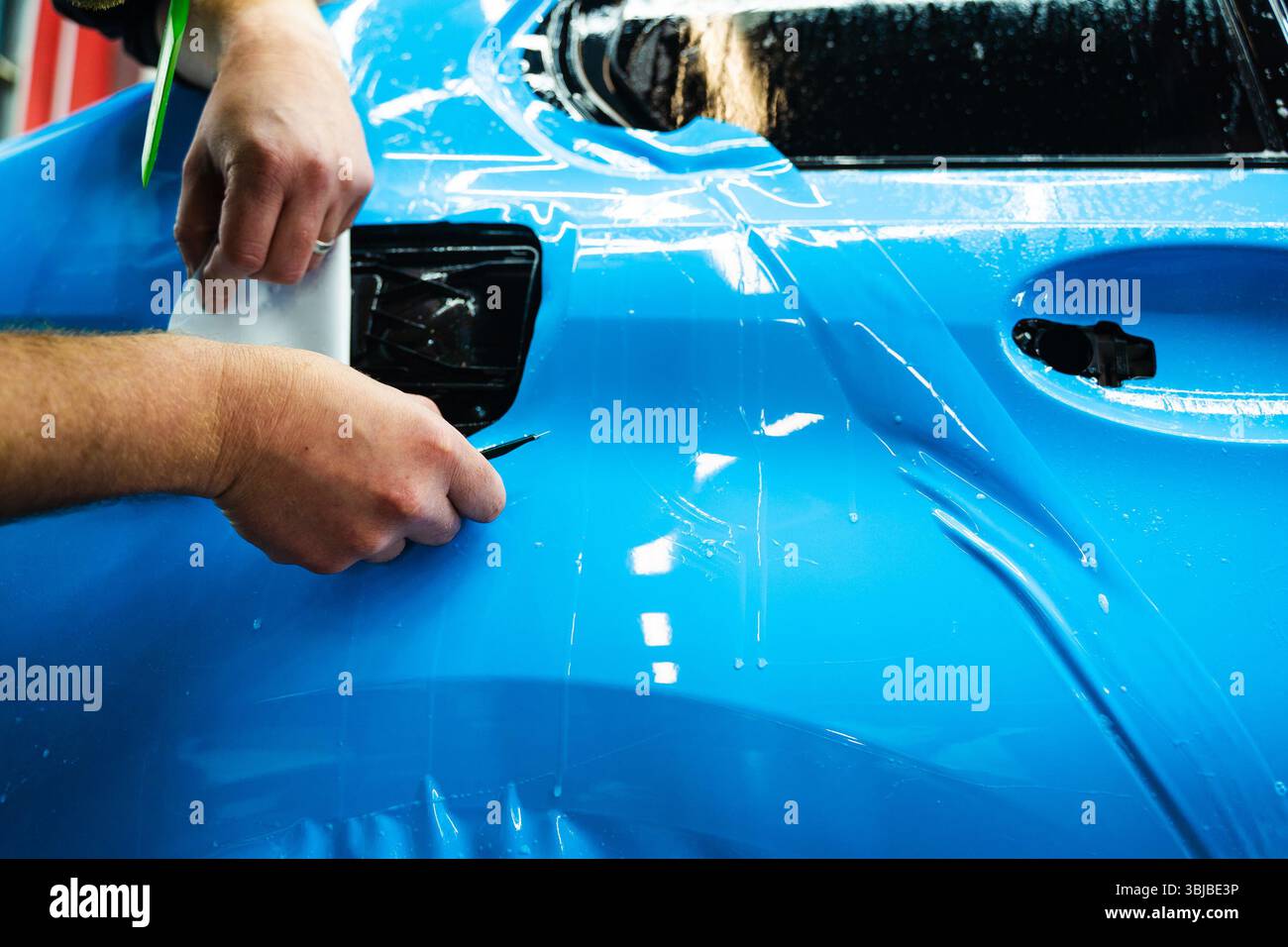 Cutting blue PPF with blade. Cutting blue paint protection film with ...