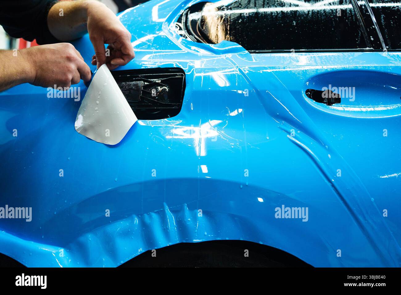 Cutting blue PPF with blade. Cutting blue paint protection film with ...