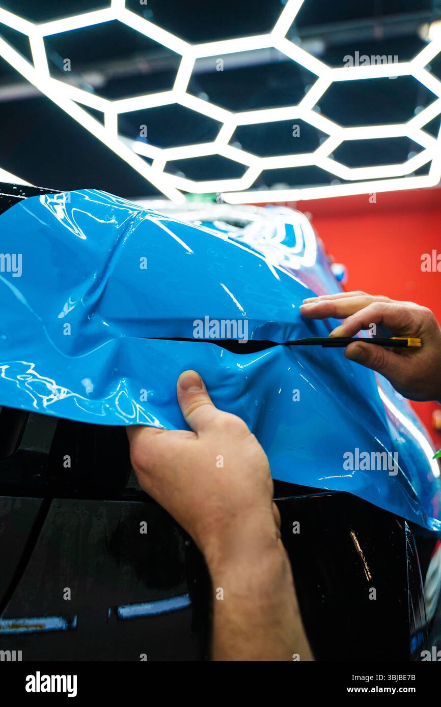 Cutting blue PPF with blade. Cutting blue paint protection film with ...