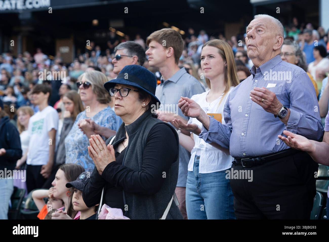 People raise their hands while singing "Our Father" the Archdiocese of ...