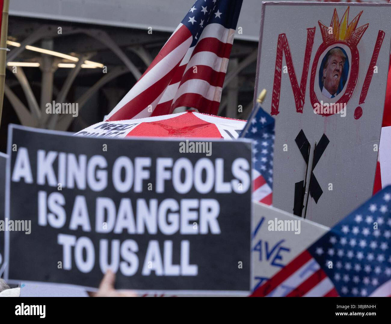 Marchers carry signs during the No Kings Rally 14 June 2025 in New York ...