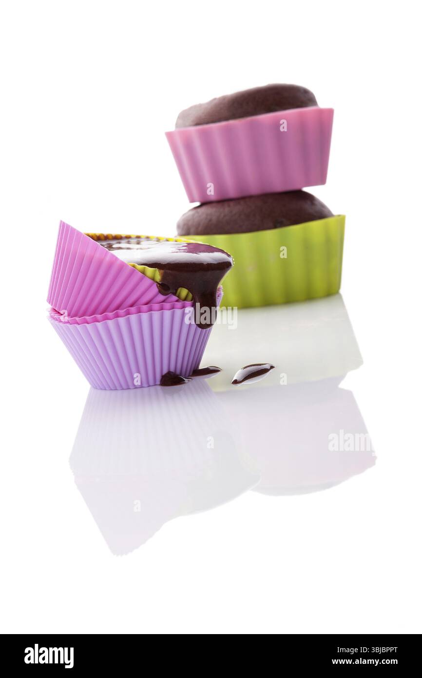 Cupcake mixture dropping from baking form isolated on white background ...