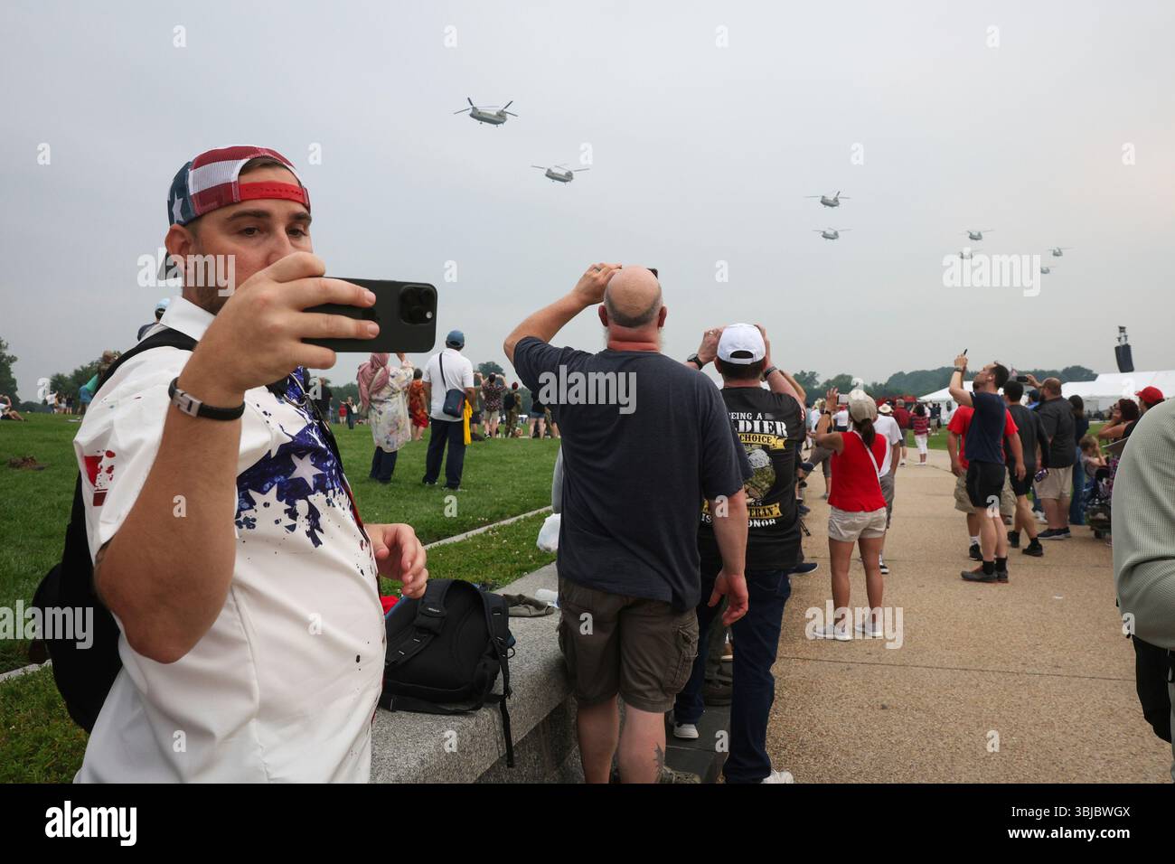 Spectators film a flyover during a military parade commemorating the U ...