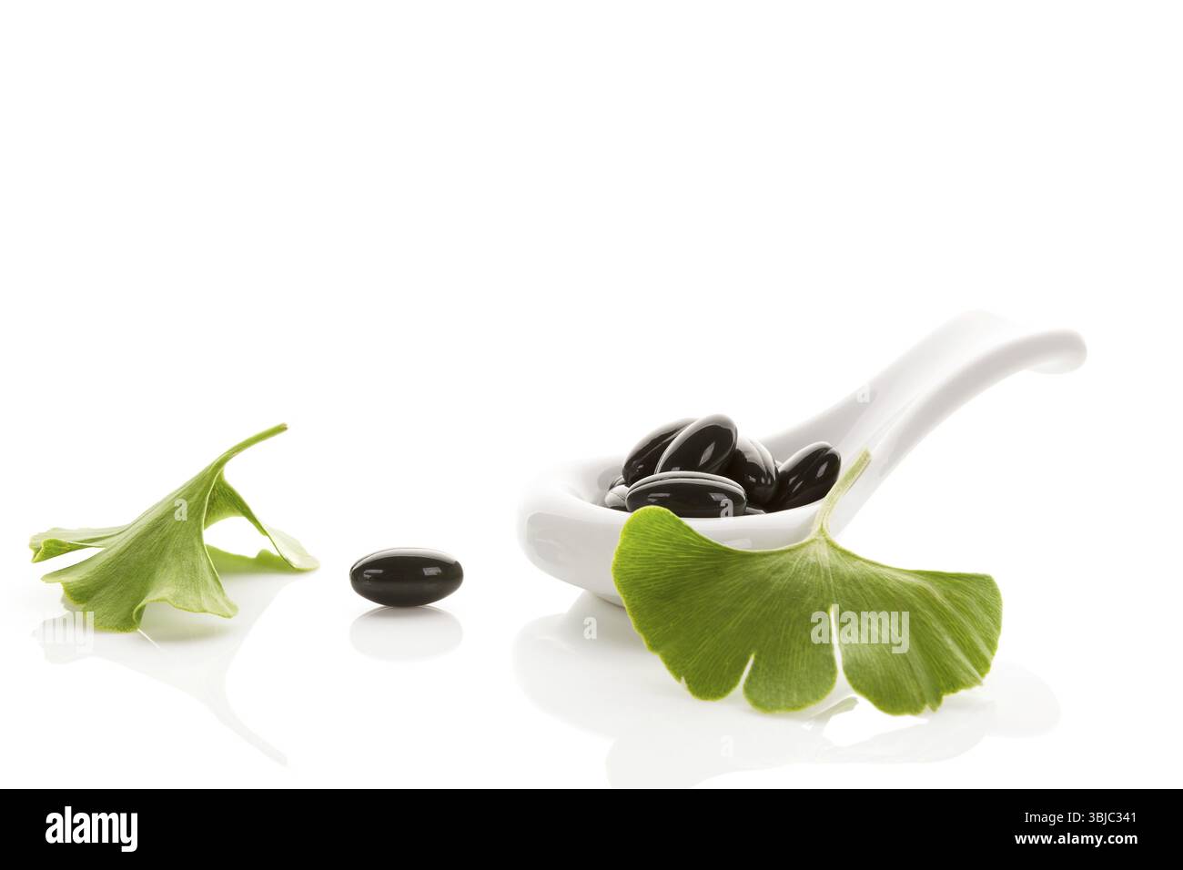 Ginkgo leaves with gel capsules isolated on white background with ...