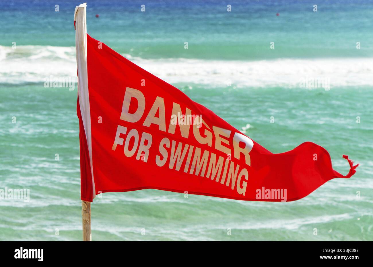 Danger for swimming red flag on the beach Stock Photo - Alamy