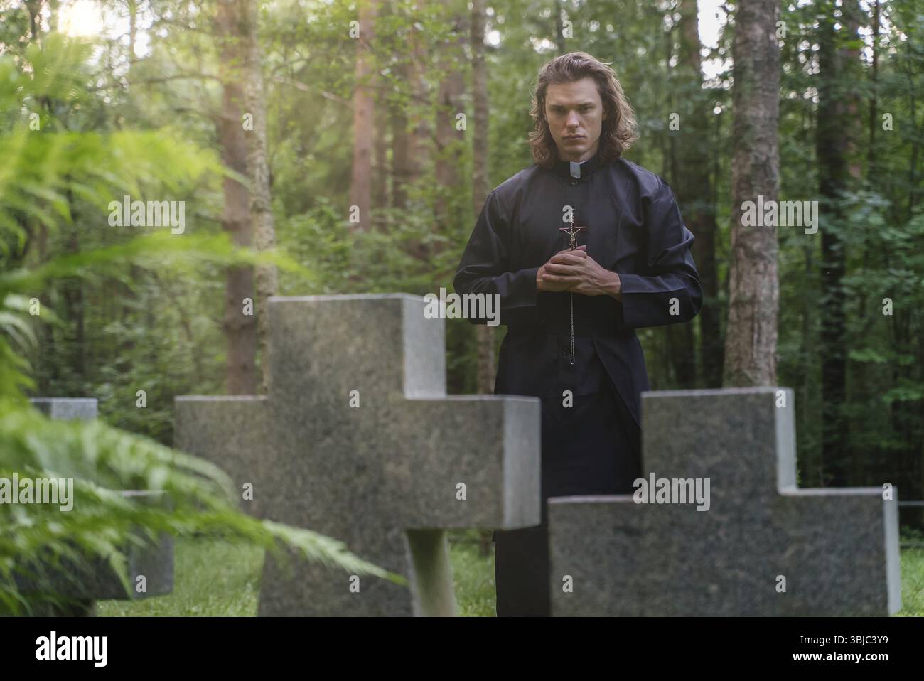 Christian priest with cross on the cemetery Stock Photo - Alamy