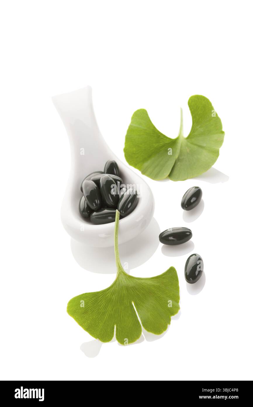 Ginkgo leaves with gel capsules isolated on white background with ...