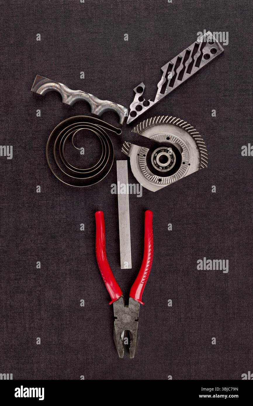 Screws, cogwheels and mechanical components on black surface from above ...