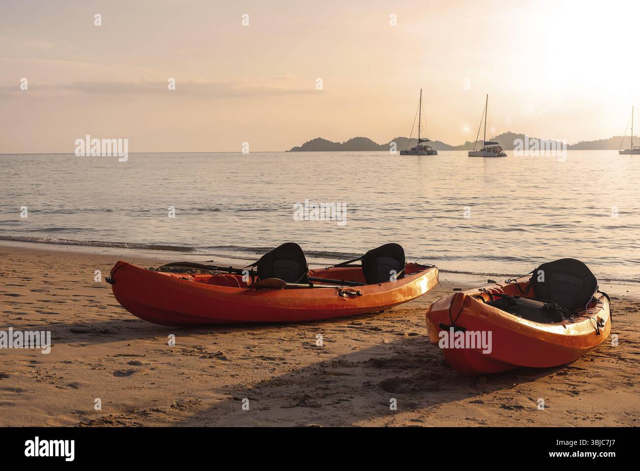 Kayaks on sandy beach during sunset. Travelling and sabbatical Stock ...