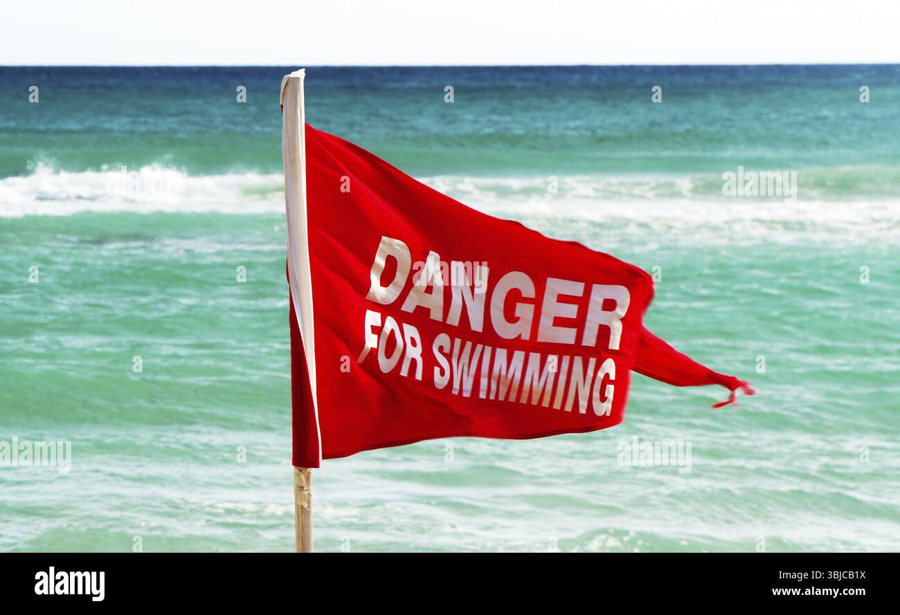 Danger for swimming red flag on the beach Stock Photo - Alamy