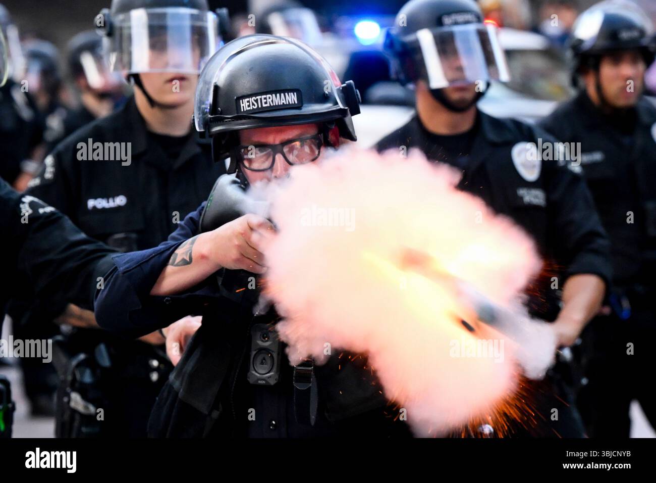 A law enforcement officer fires a less-lethal projectile during a ...