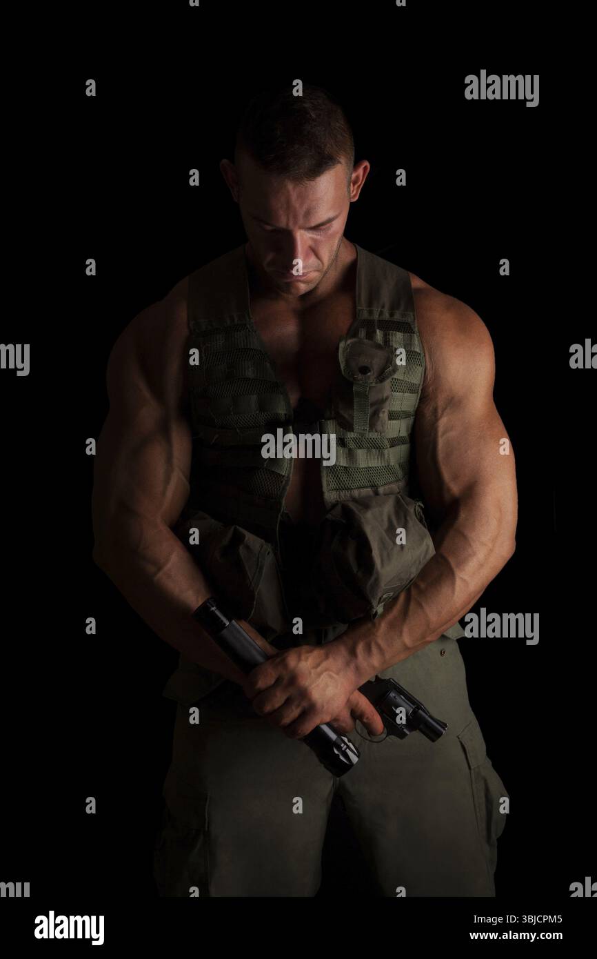Soldier with gun and flashlight in green uniform standing proud ...
