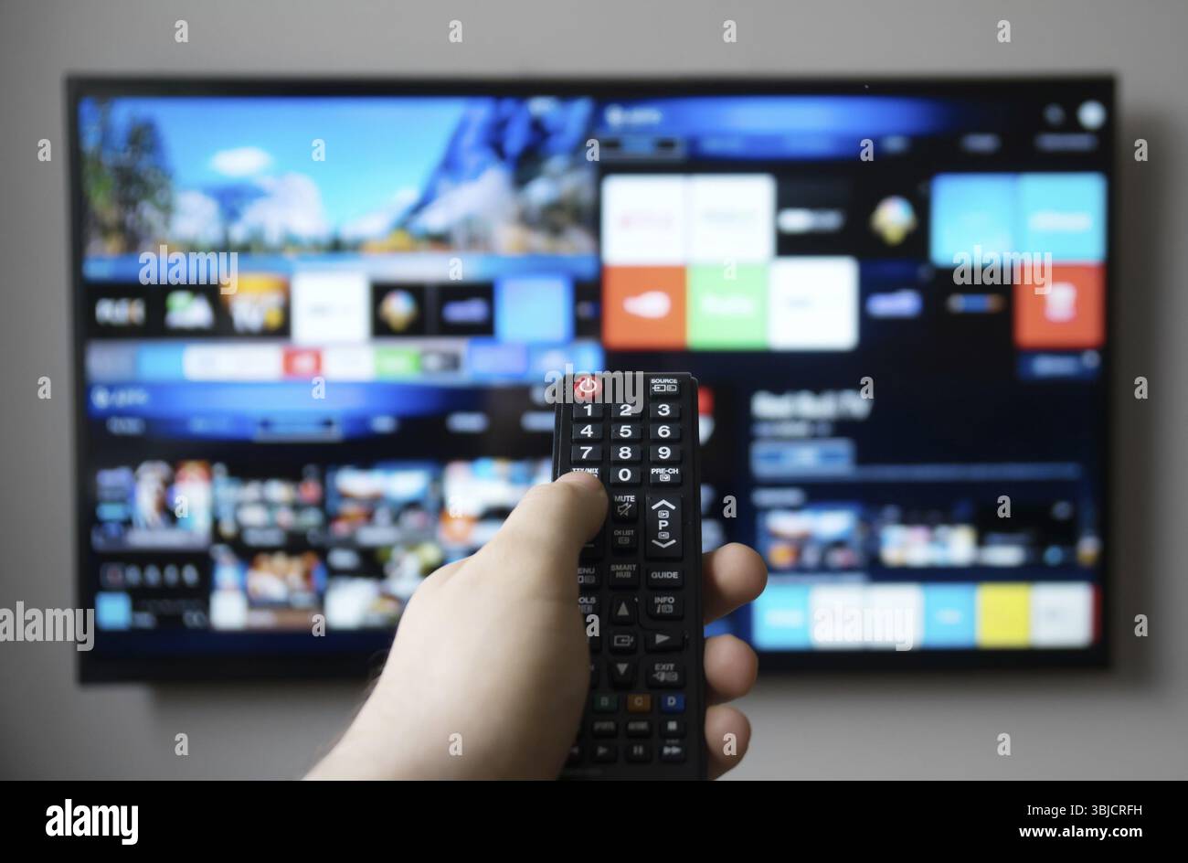 Male hand holding TV remote control. Smart TV Stock Photo - Alamy