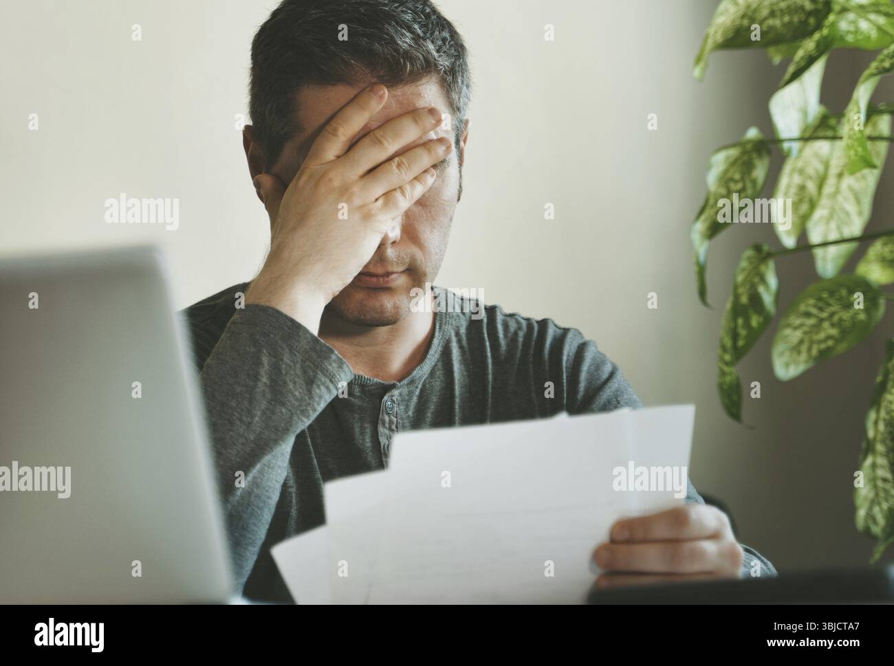 Sad man working with papers at home Stock Photo - Alamy