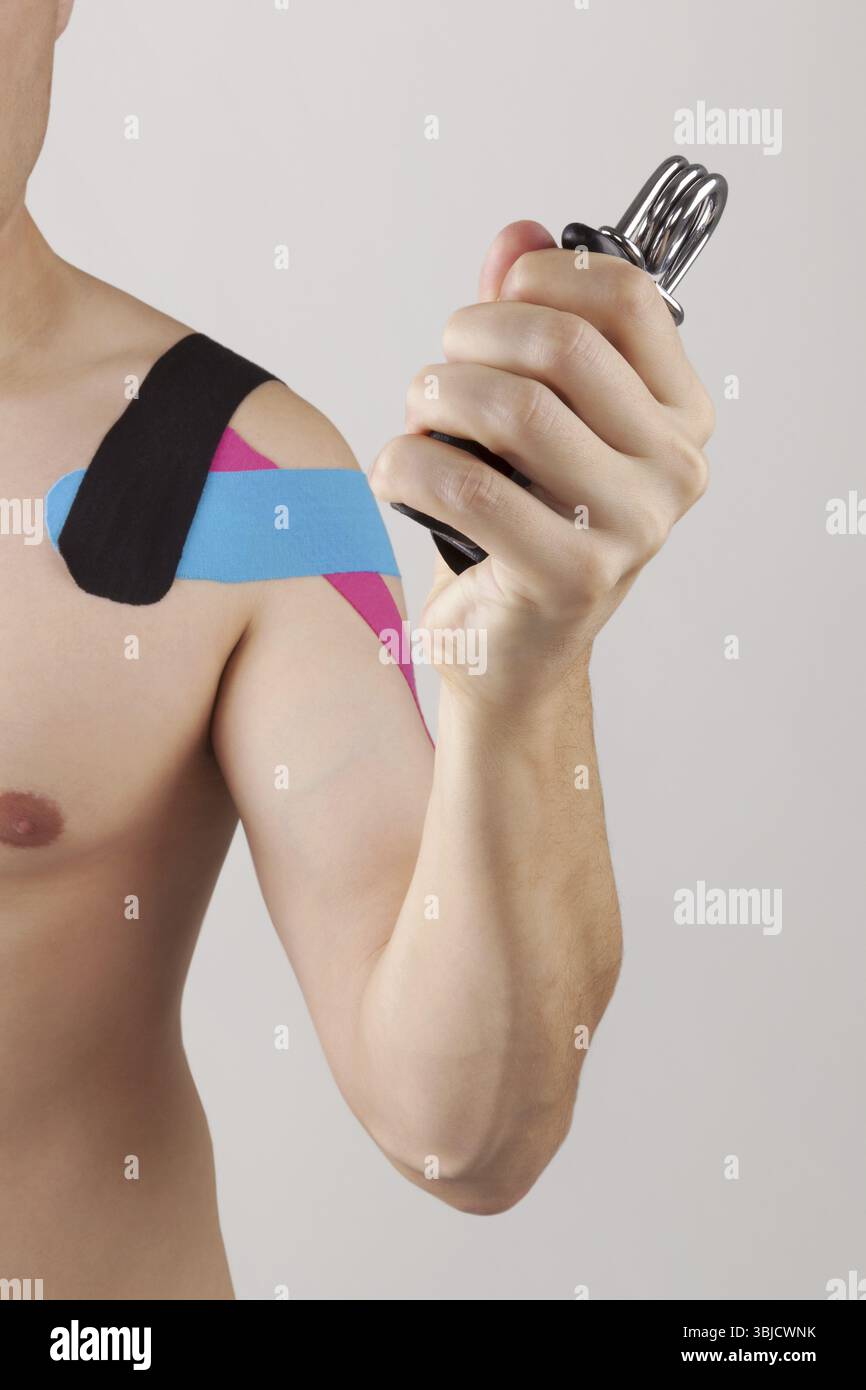 Men holding in hand grip strengthener with adjustable resistance range ...