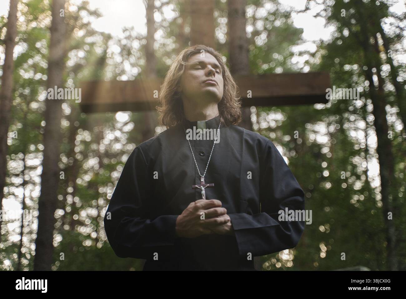 Christian priest with cross praying on the cemetery Stock Photo - Alamy
