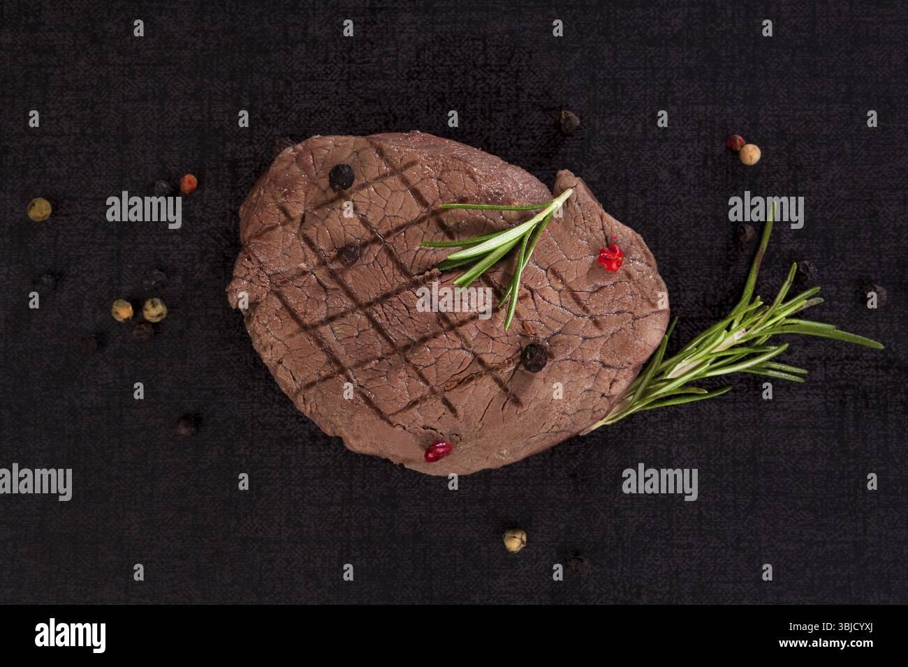 Luxurious rare tenderloin steak with herbs and peppercorn on lava rock ...