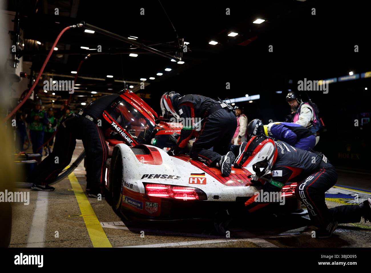 The pit crew works on the No. 4, a Porsche Penske Motorsport car ...