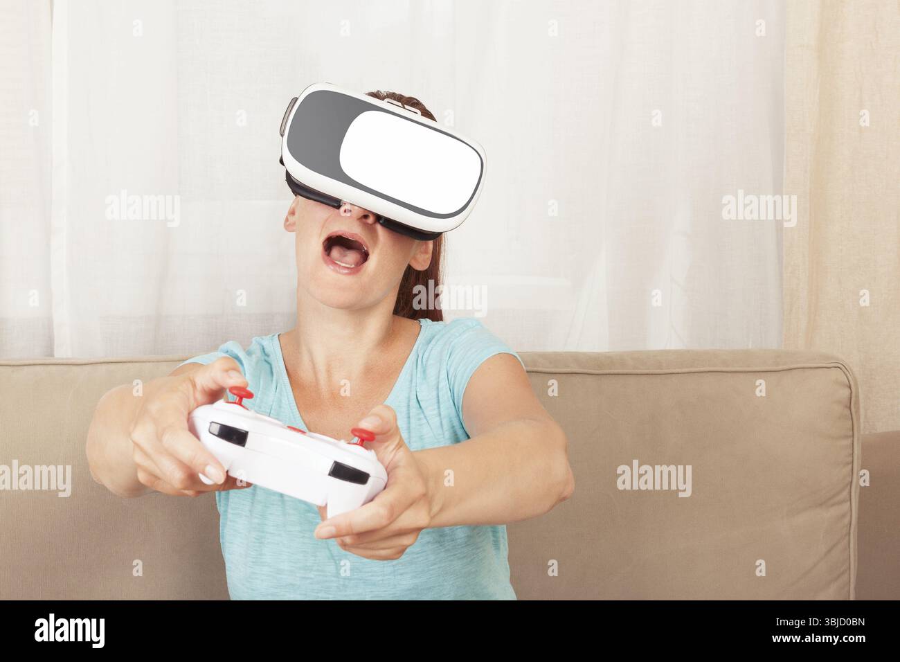 Beautiful young women wth VR headset and joystick playing virtual ...