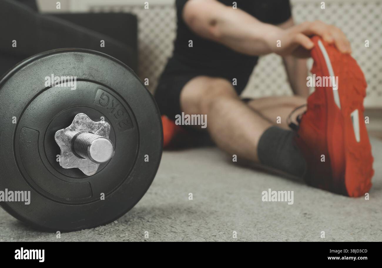 Man stretches his leg before exercise. Home fitness training concept ...