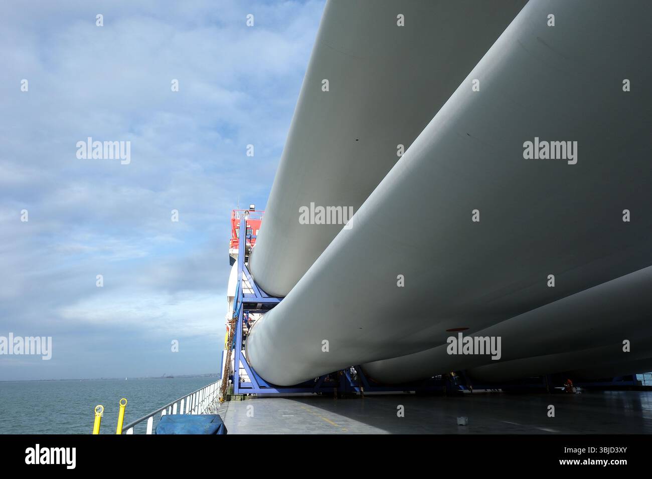 Long blades of wind turbine loaded and lashed on the heavy load carrier vessel passing Nord Sea ...