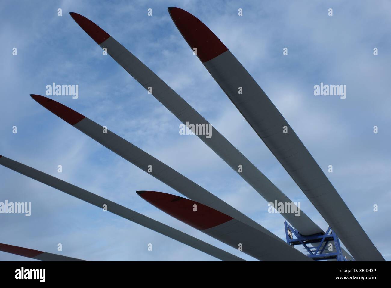 Red end tips of long blades of wind turbine loaded and lashed by slings ...
