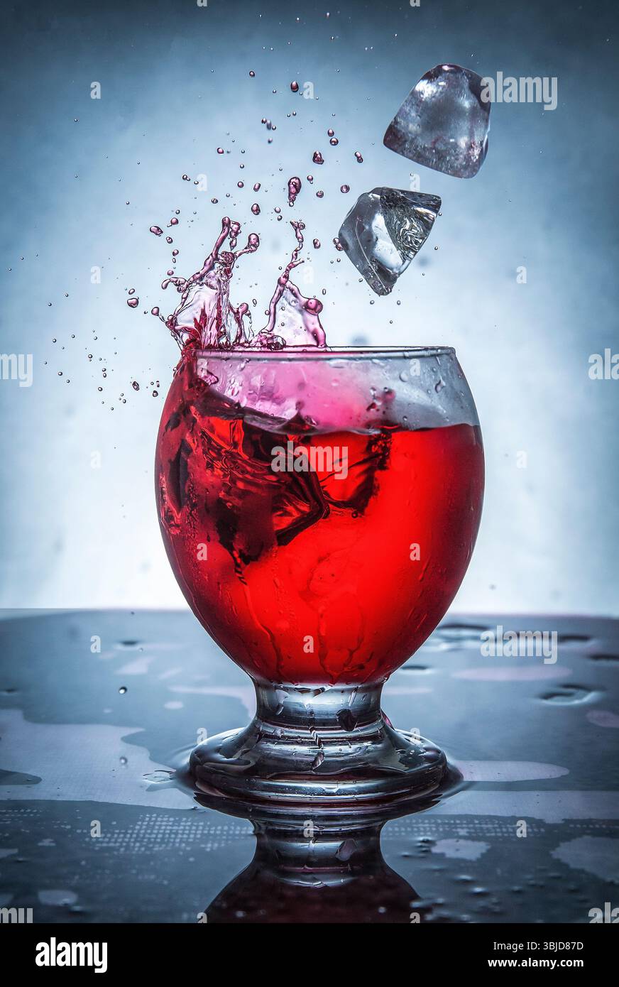 Red juice splash with ice Stock Photo - Alamy