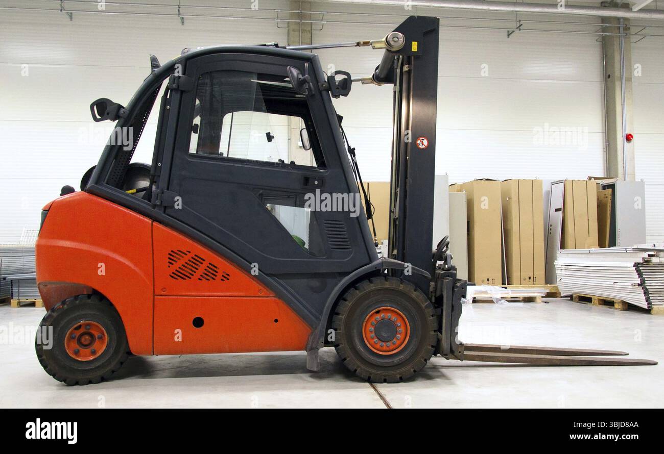 Orange forklift loader in the modern warehouse Stock Photo - Alamy