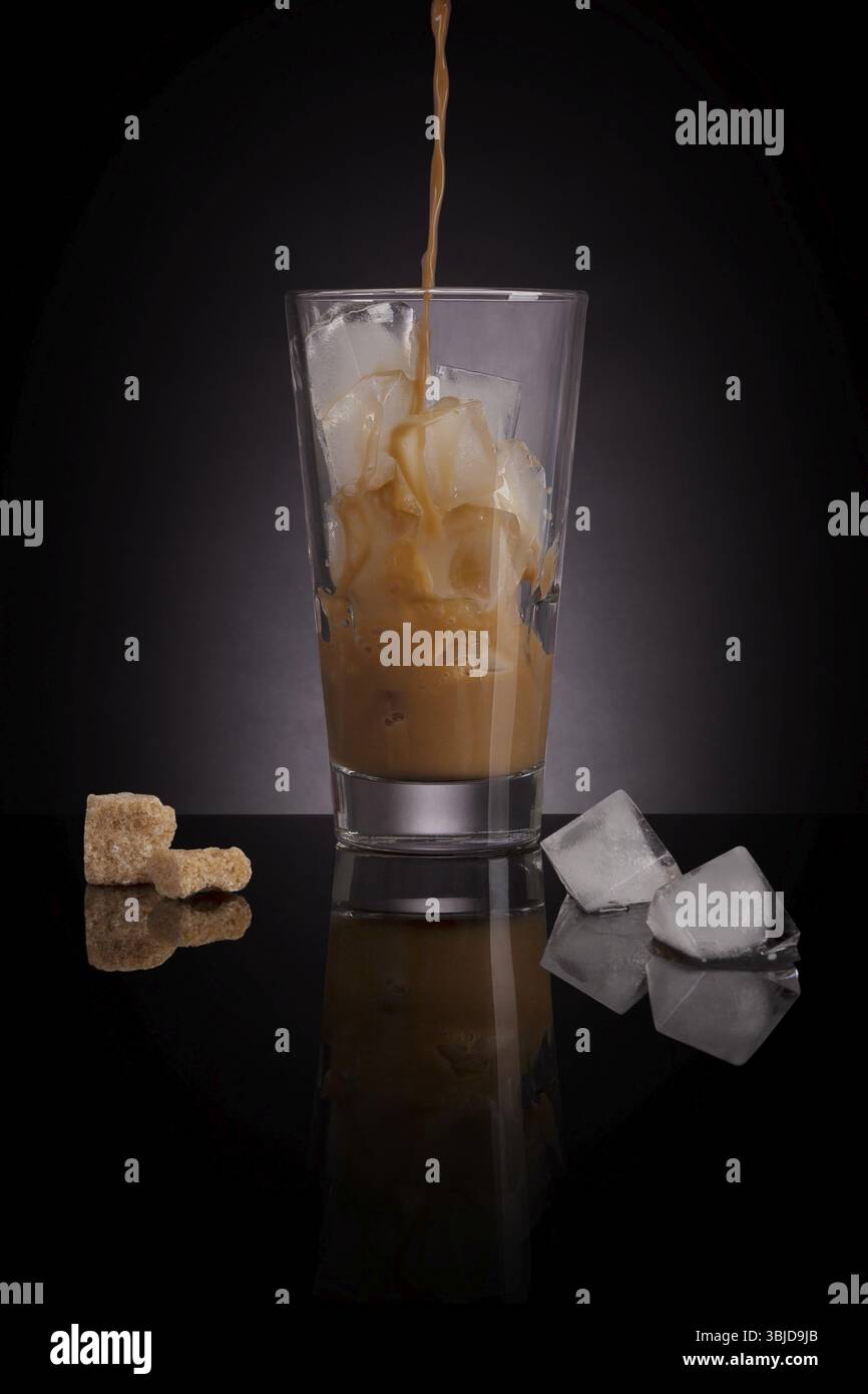 Delicious ice coffee with melting ice cubes and brown sugar on dark ...